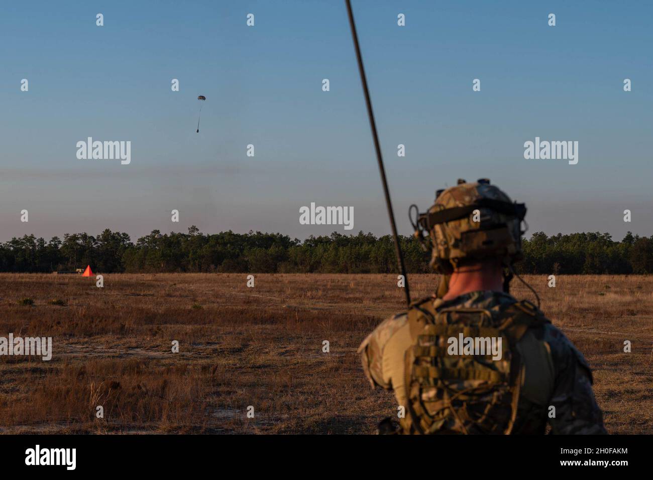 A U.S. Air Force Special Tactics operator watches bundles descend to ...