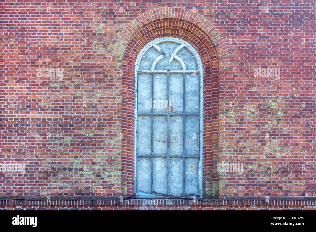 Arched window opening with an old wooden frame on the background of an ...