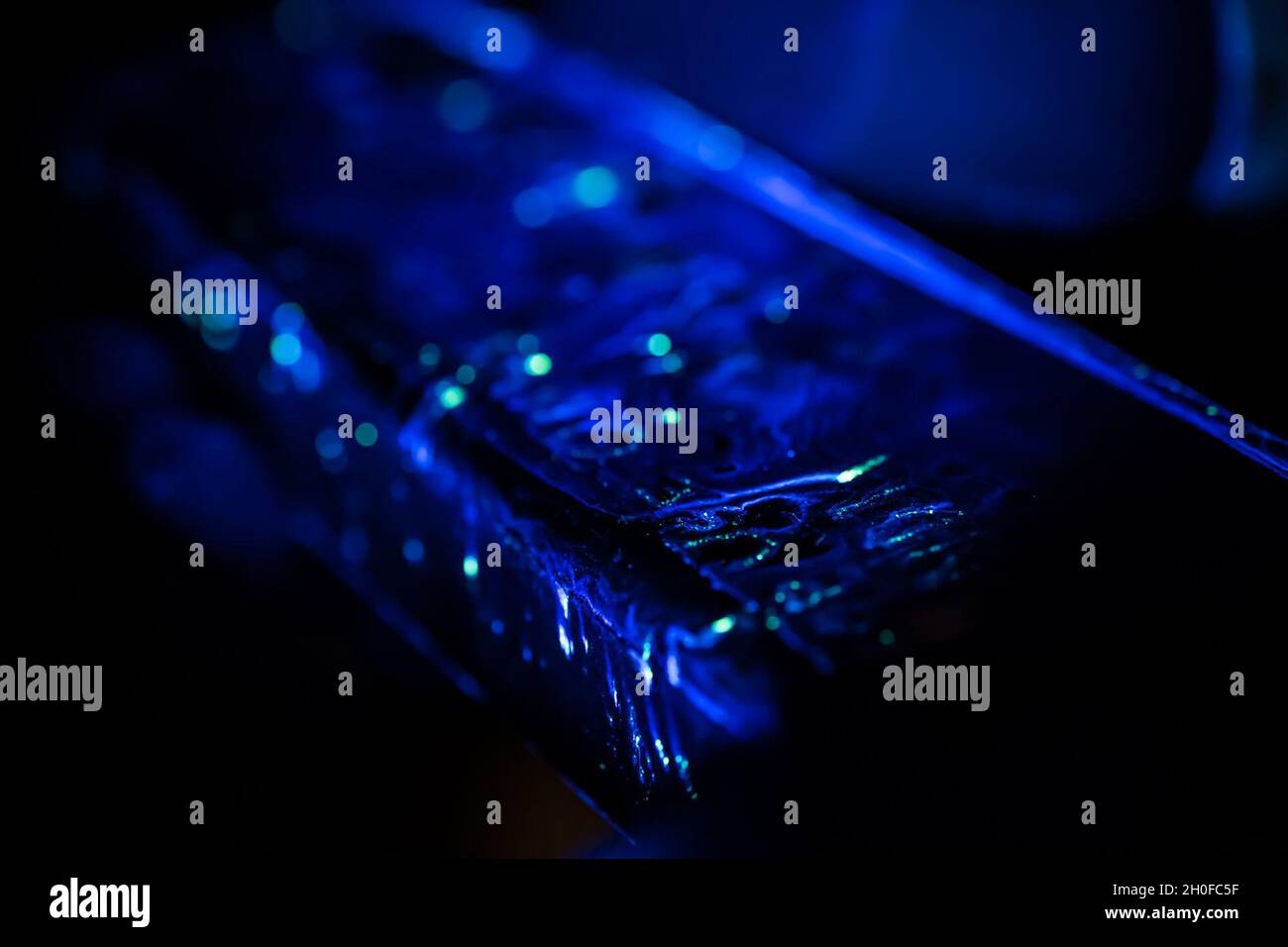 Black light shines on a metal fitting during a non-destructive ...