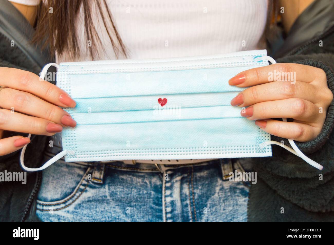 Holding a mask with a little heart on it Stock Photo - Alamy