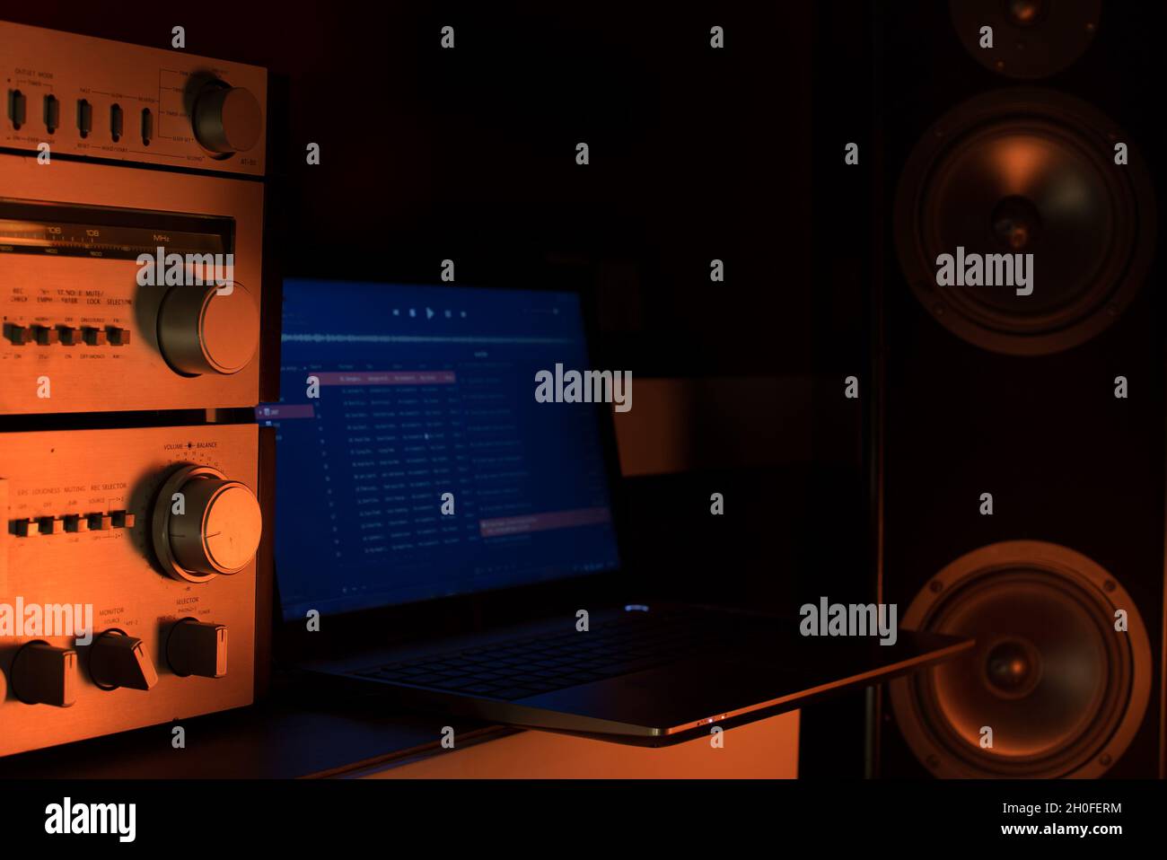 Laptop playing music on big loudspeakers with amplifier. Home sound ...