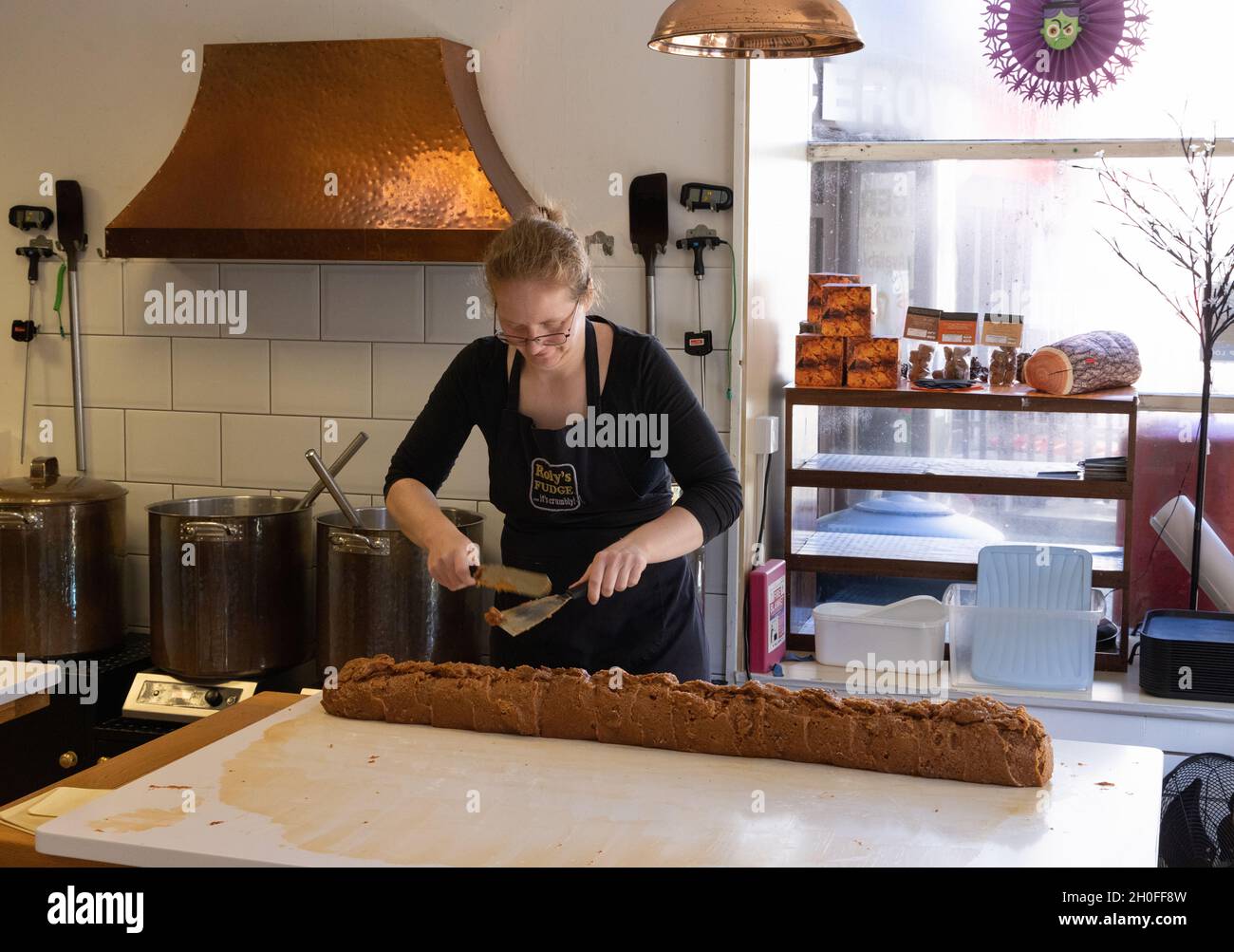 A woman making fudge, a type of confectionery, in the interior of Roly ...