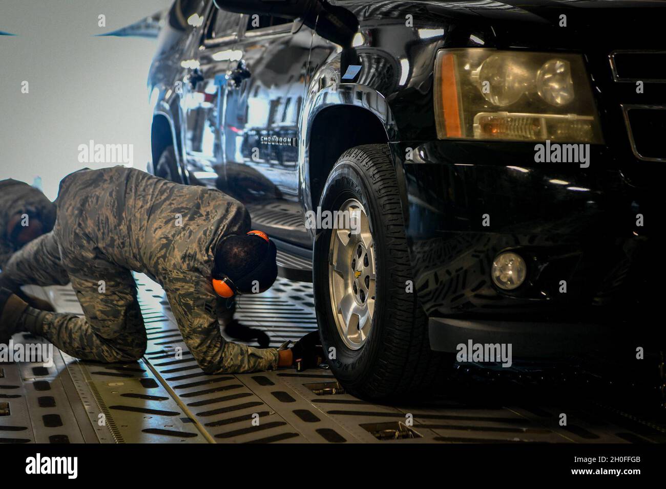 Airmen chain an FBI Suburban onto a C-17 during a joint exercise at ...
