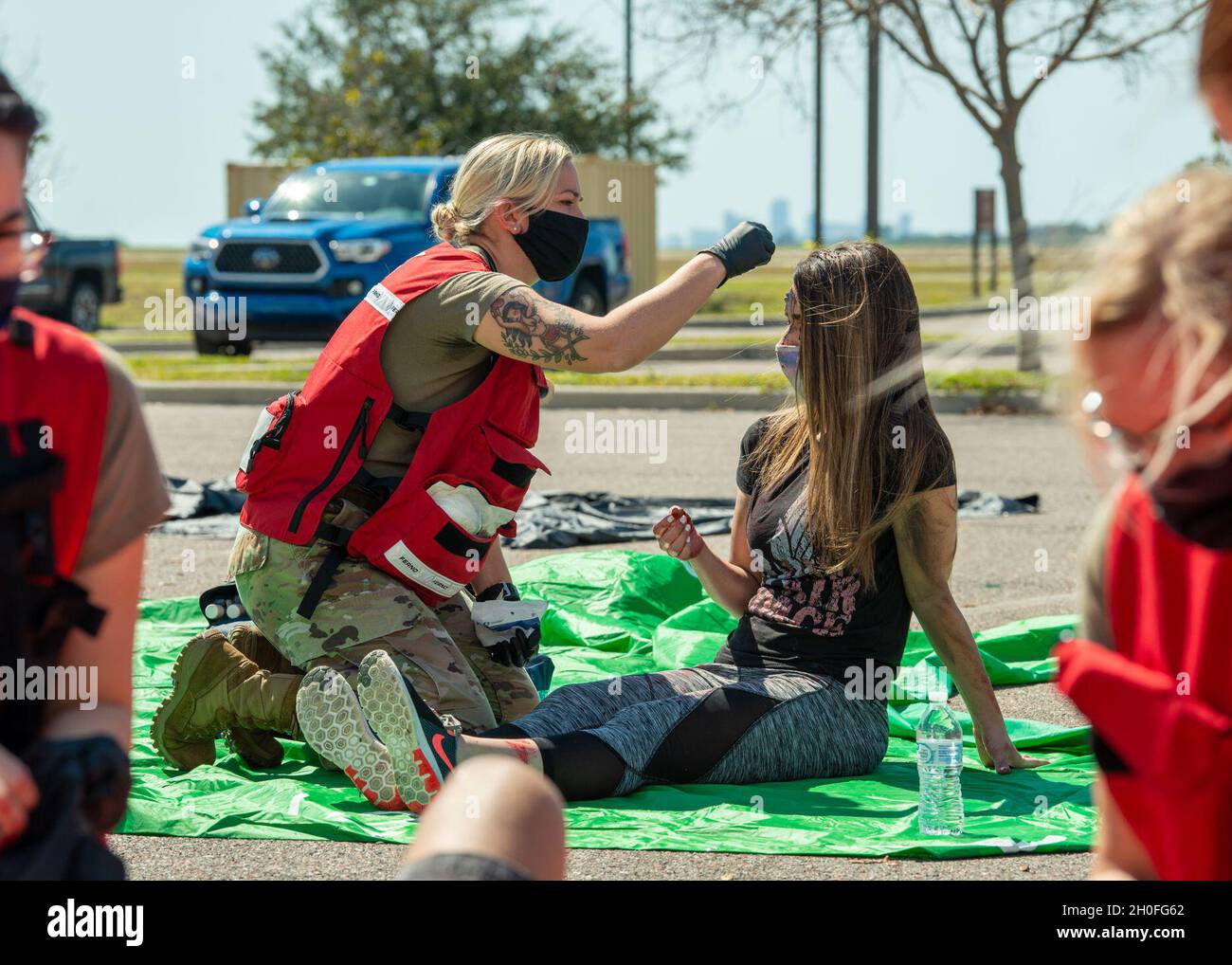 A 6th Medical Group emergency responder places a bandage on a simulated ...