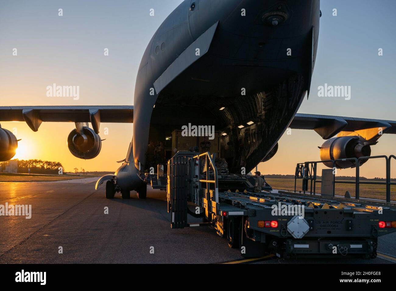 A K-loader is positioned to a ramp of a Dover Air Force Base C-17 ...