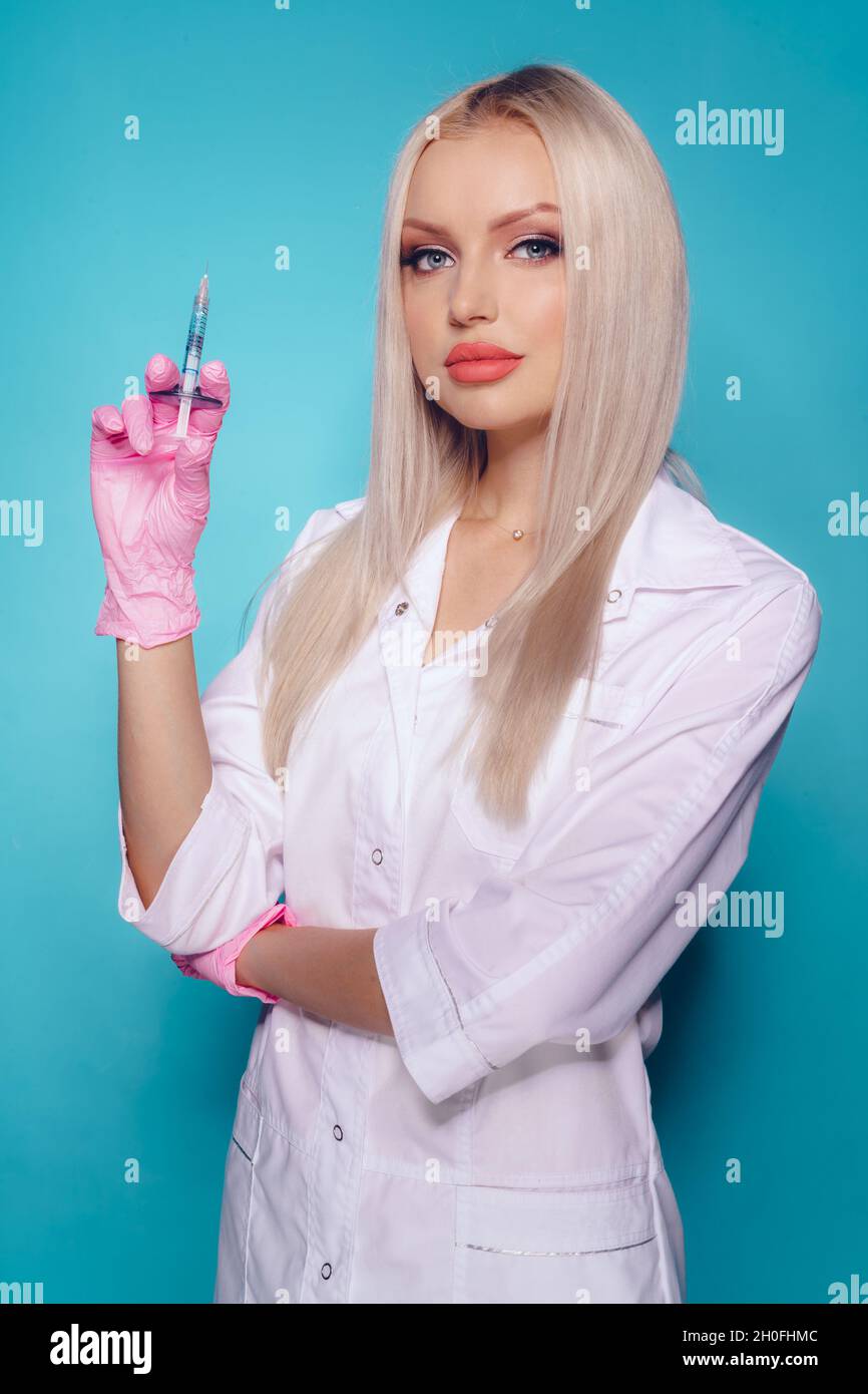Beautiful young woman doctor beautician in medical uniform holding ...