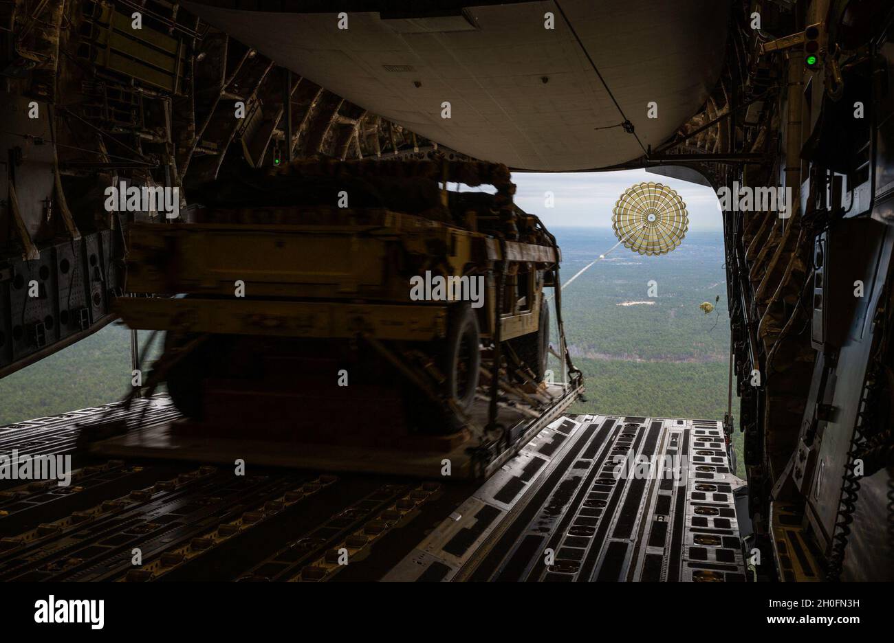 A Humvee is airdropped from a C-17 Globemaster III, assigned to the ...