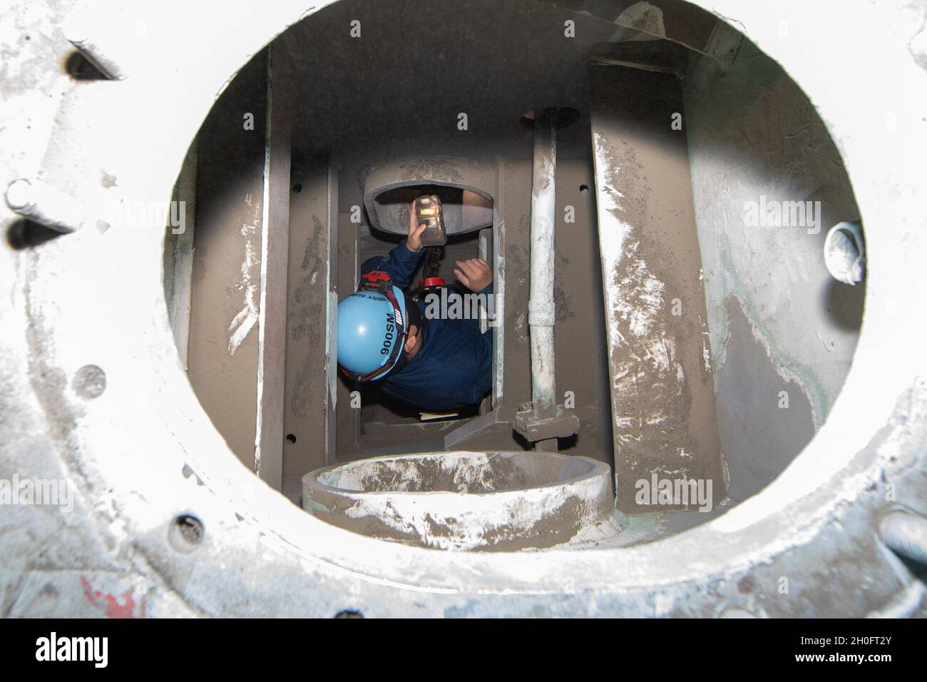 A SurgeMain (Surge Maintenance) Sailor crawling down a mock up confined ...