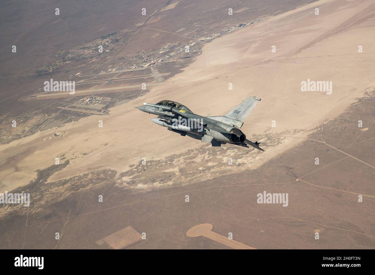 An F-16 assigned to the 416th Flight Test Squadron flies into position ...