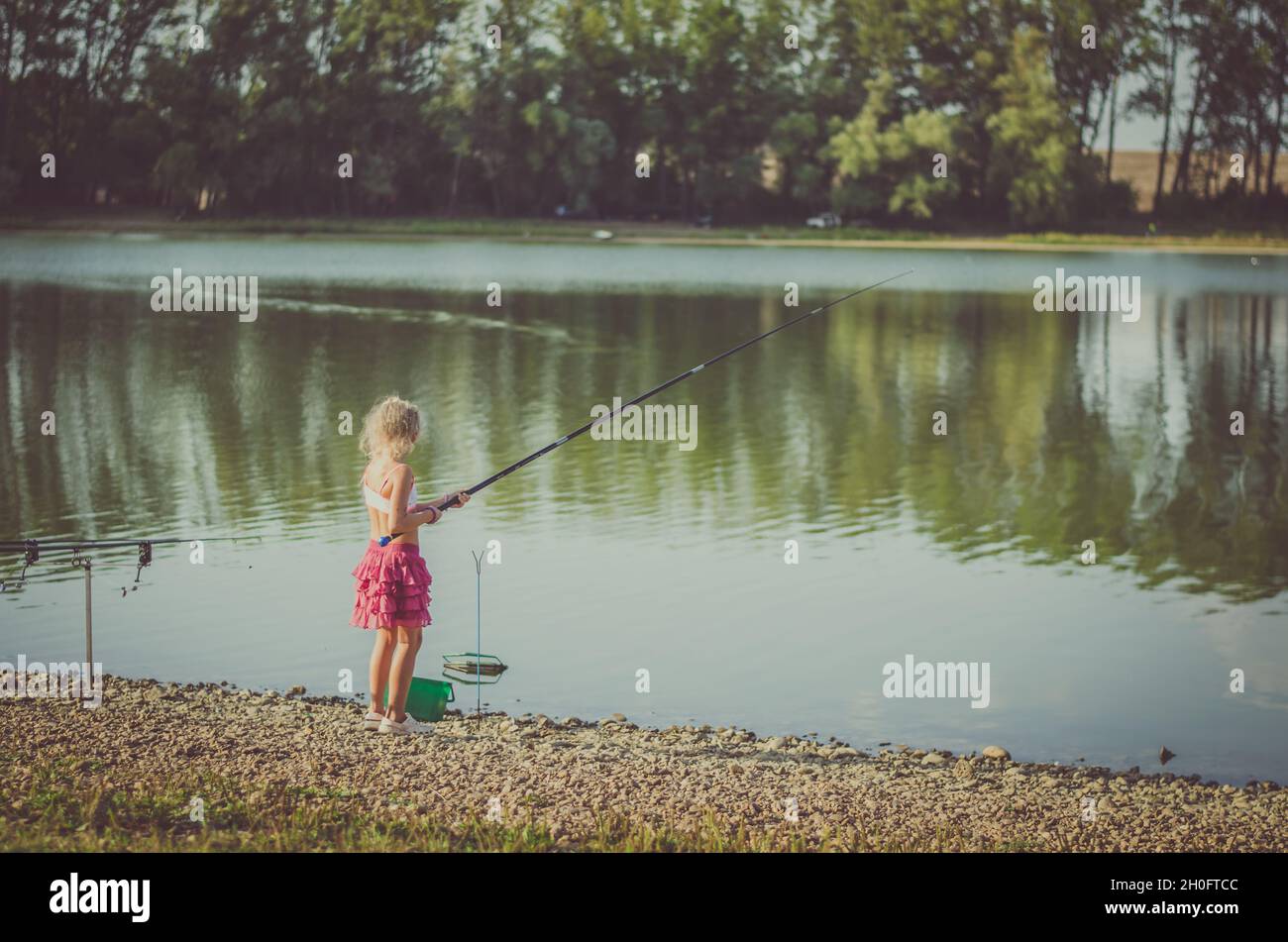 lovely girl with fishing rod at the pond Stock Photo - Alamy