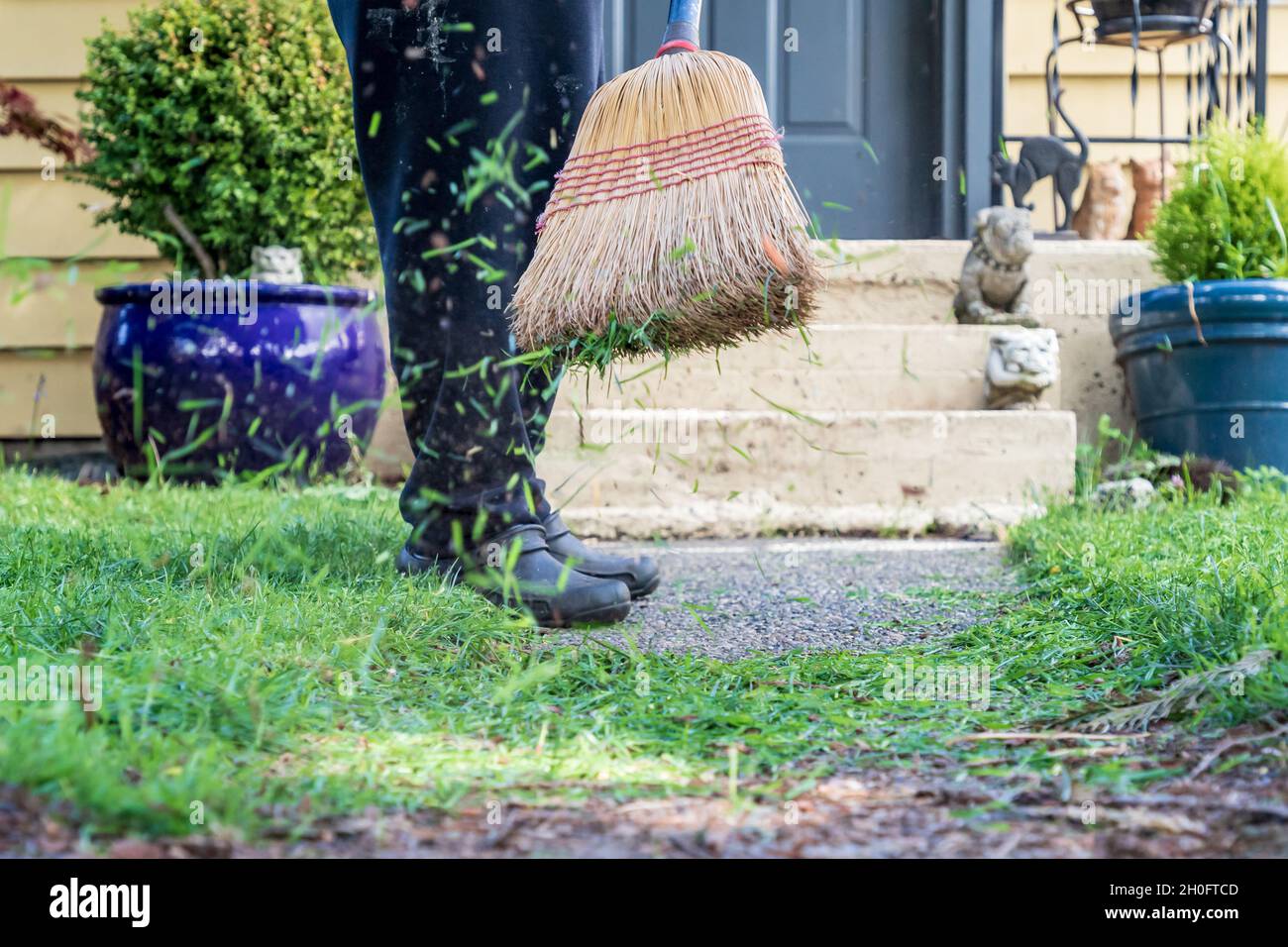 Person Sweeping grass off sidewalk Stock Photo - Alamy