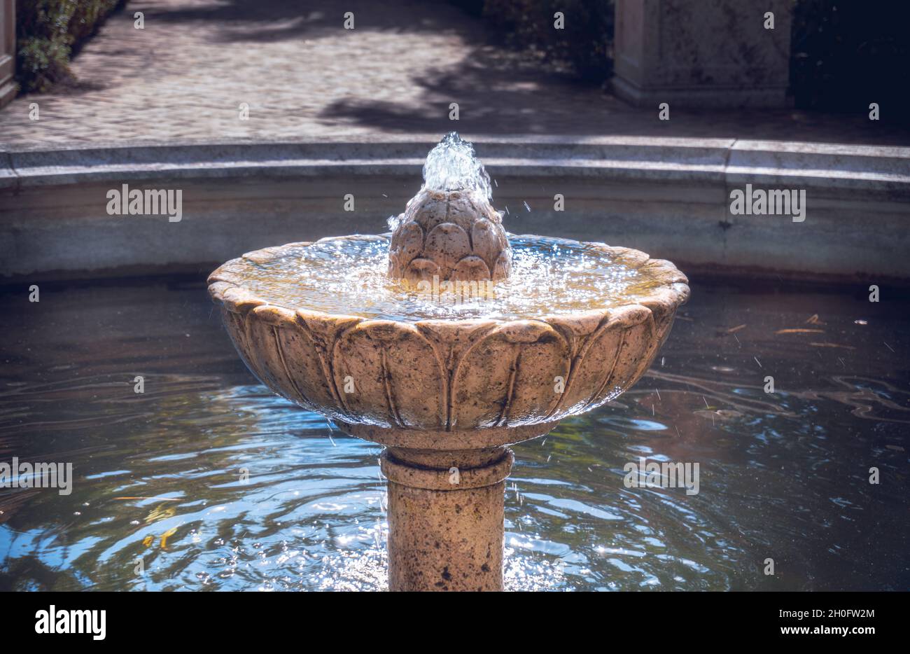 Closeup shot of a vintage fountain in the garden under the sunlight ...