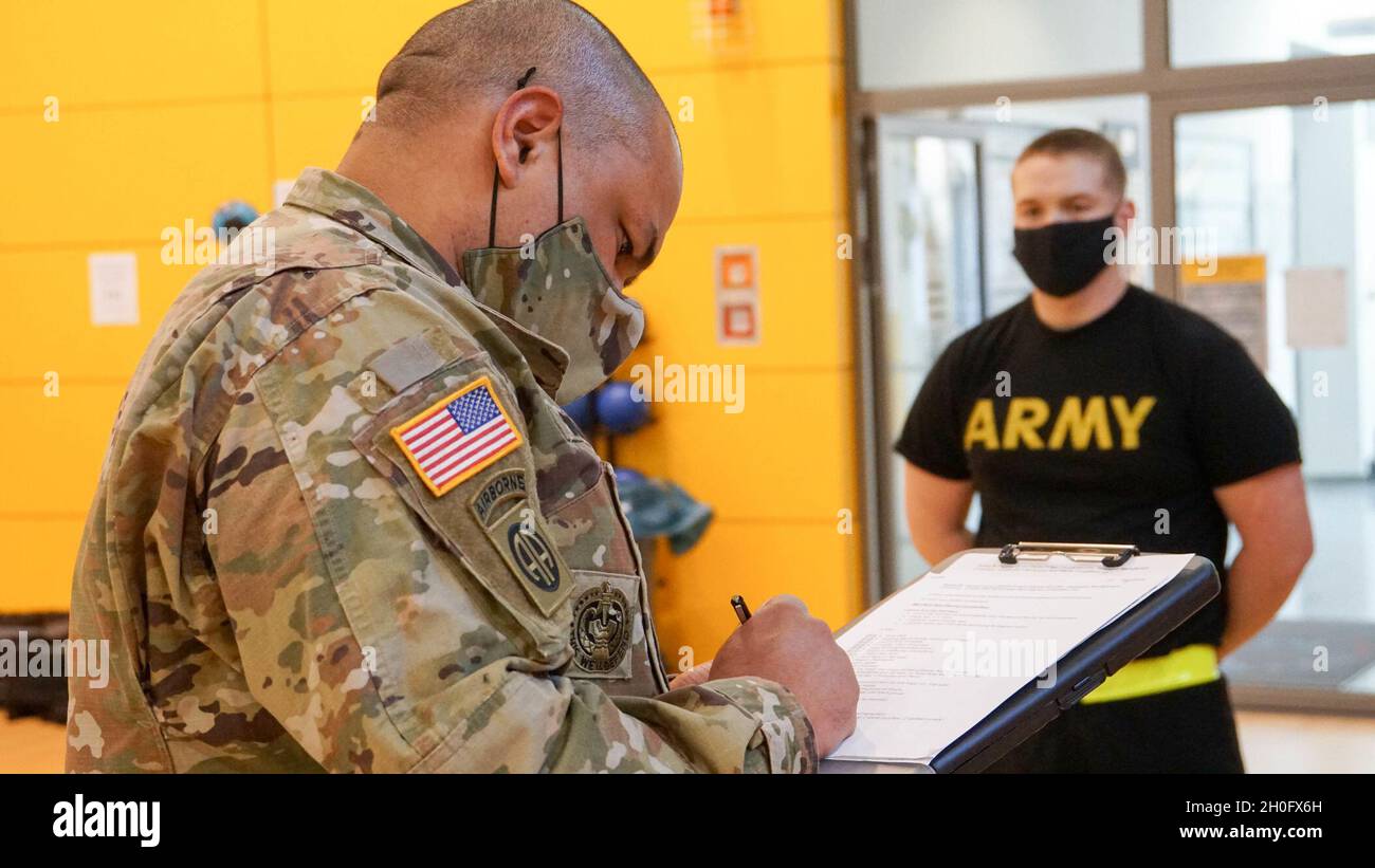 A soldier looks on as an NCO judges his equipment layout at the ...