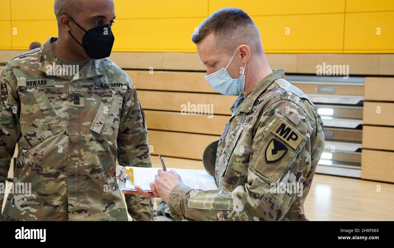 A pair of NCO's discuss and score a soldiers equipment layout on Feb ...