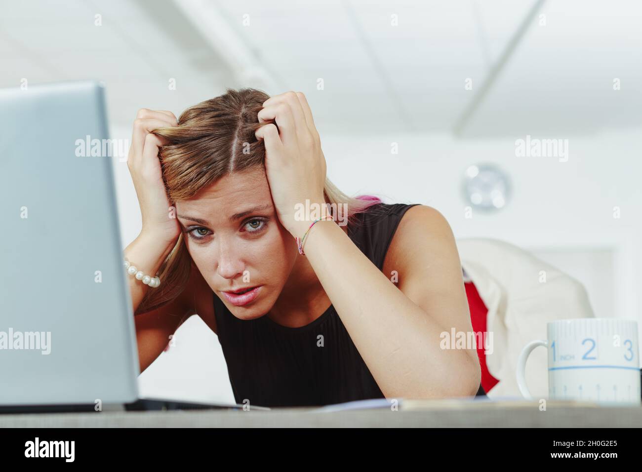 Frustrated stressed businesswoman with head in hands leaning over her ...