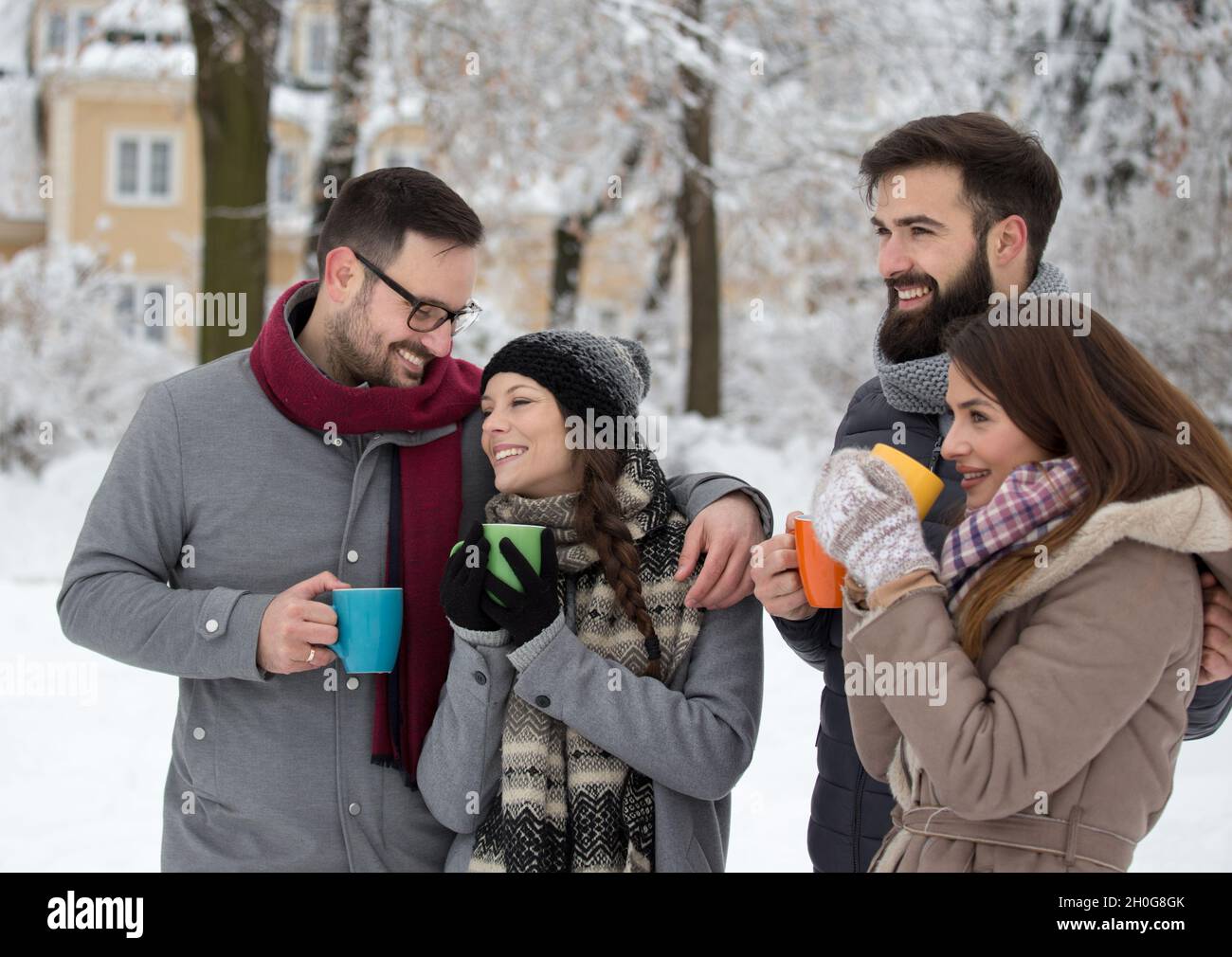 Small group of friends drinking hot chocolate on snow in forest Stock ...