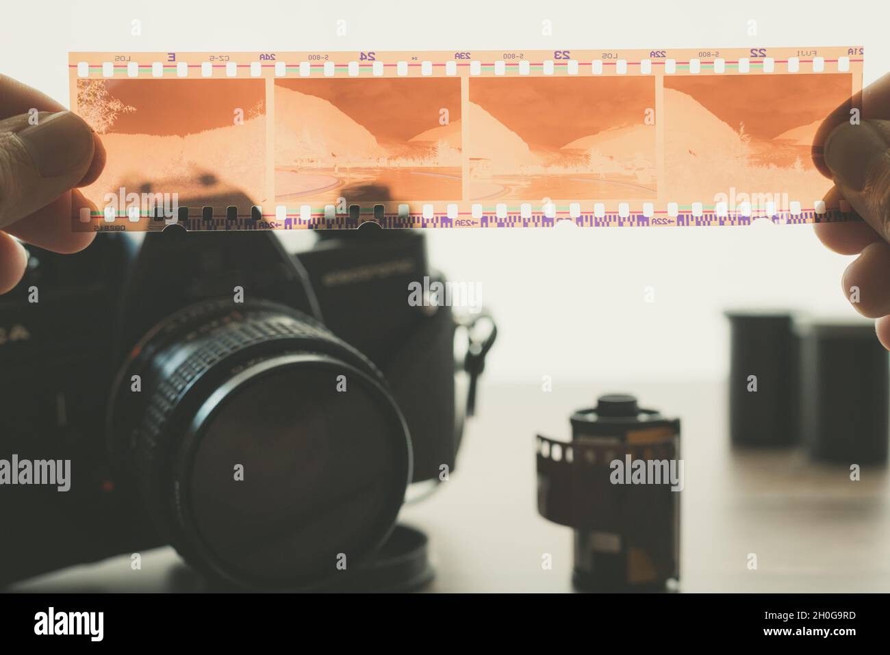 Holding Up a Negative Filmstrip with Vintage Film Camera in Background ...