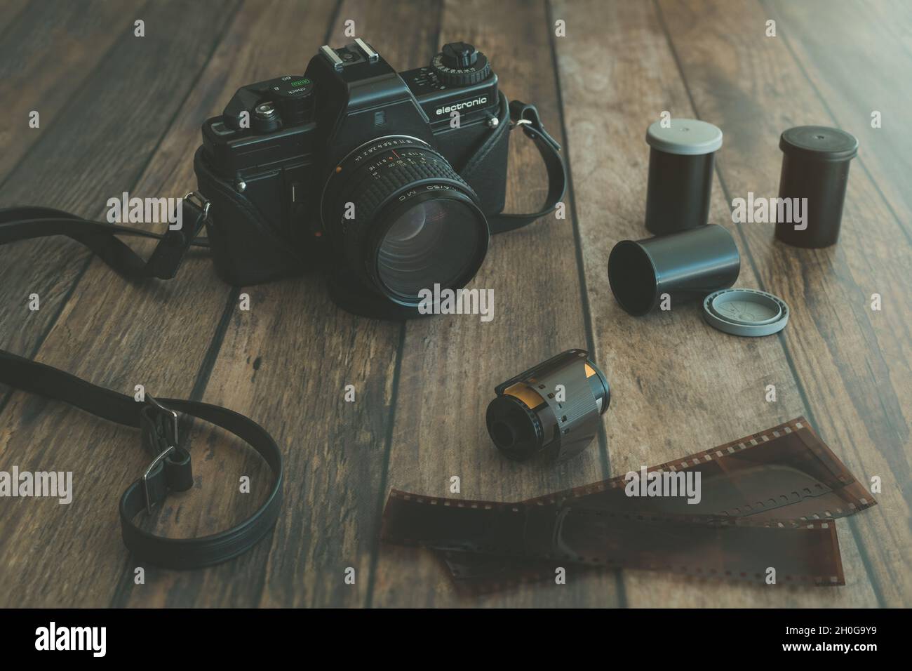 Vintage Film Camera with Filmstrip and Rolls of Film on Wood Surface ...