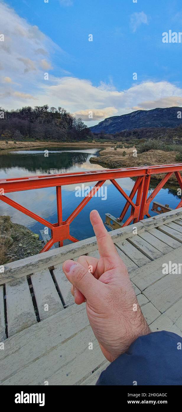 Vertical shot of a human hand with forefinger showing mountains and the ...