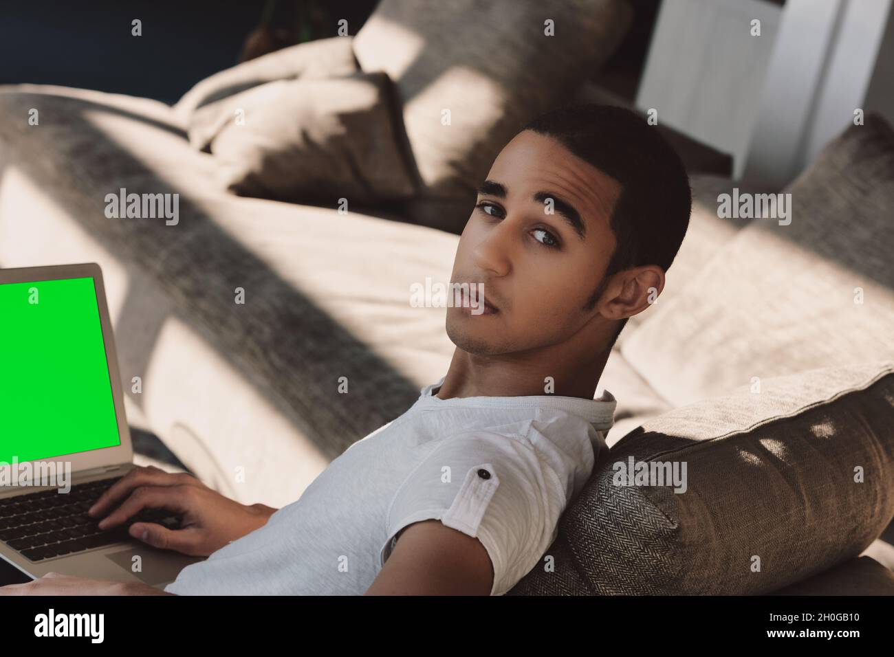 Young Black man turning to give the camera a questioning look as he ...