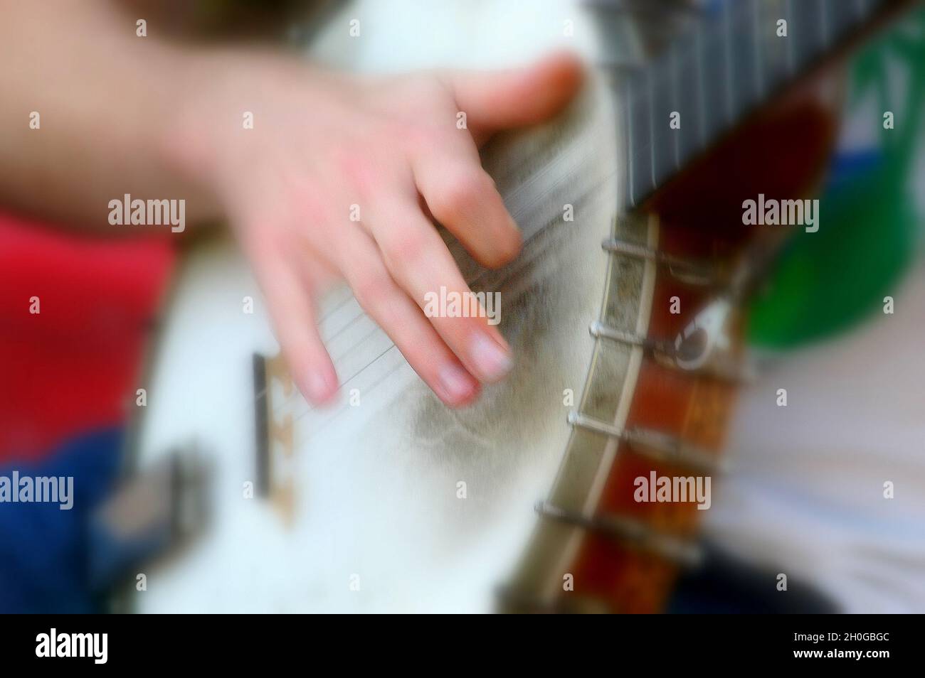 Closeup soft-focus shot of a hand playing a stringed musical instrument ...