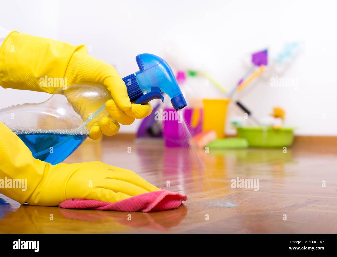 Close up of house keeper's hand splashing detergent with spray bottle ...