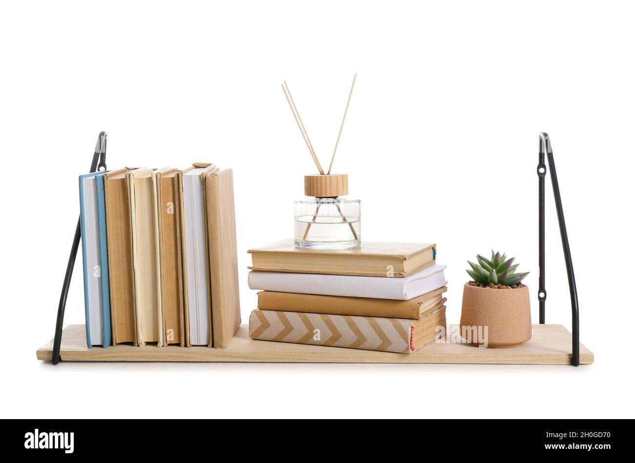 Wooden book shelf with flowerpot and reed diffuser on white background ...
