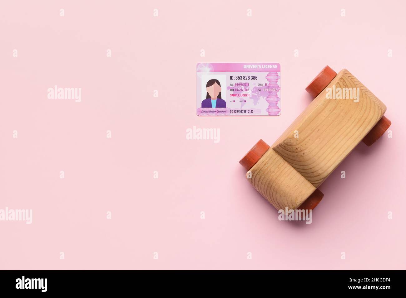 Driving license and wooden car on pink background Stock Photo - Alamy
