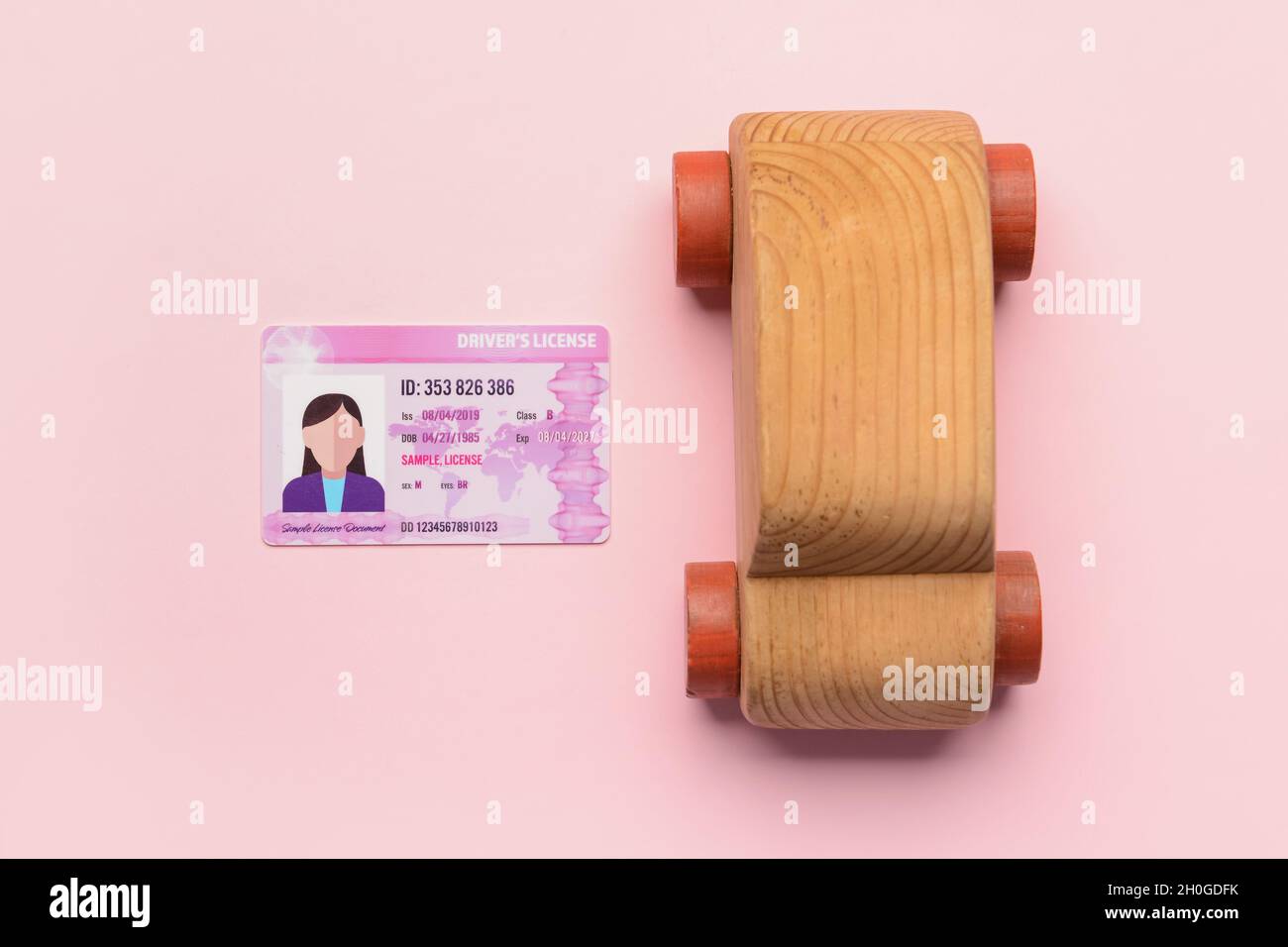 Driving license and wooden car on pink background Stock Photo - Alamy