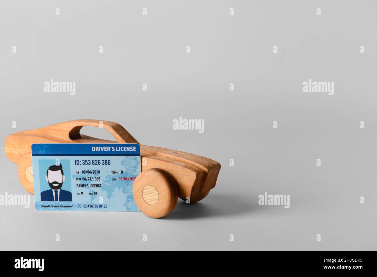 Wooden car and driving license on grey background Stock Photo - Alamy