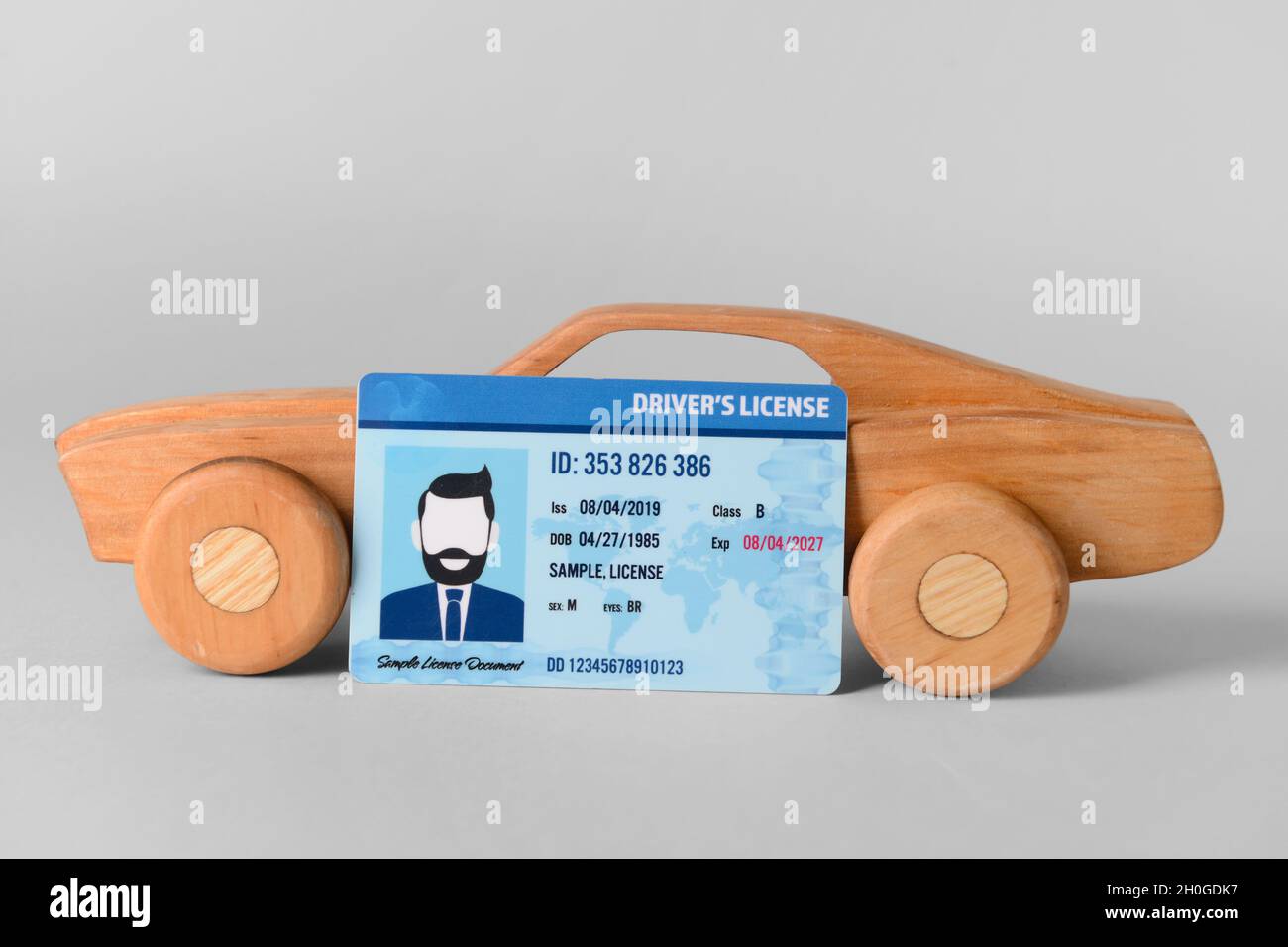 Wooden car and driving license on grey background Stock Photo - Alamy