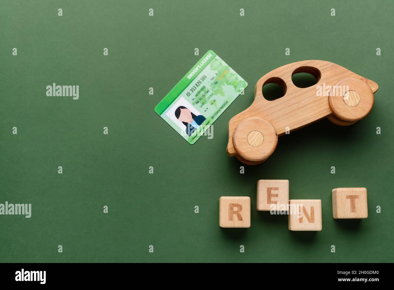 Wooden car with word RENT and driving license on green background Stock ...