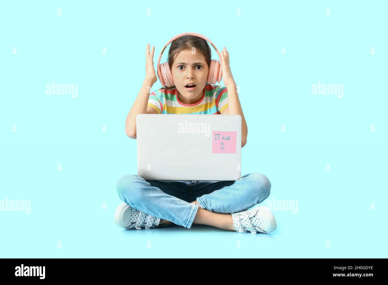 Shocked little programmer with laptop on color background Stock Photo ...