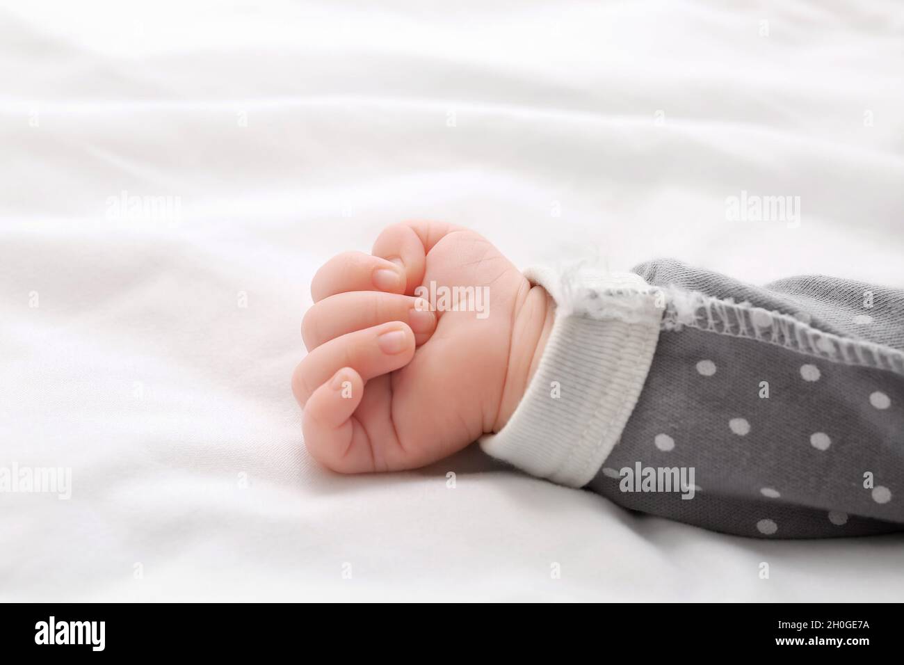 Adorable baby arm on bed, closeup Stock Photo - Alamy