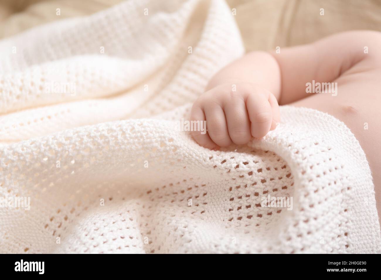 Adorable baby arm on bed, closeup Stock Photo - Alamy