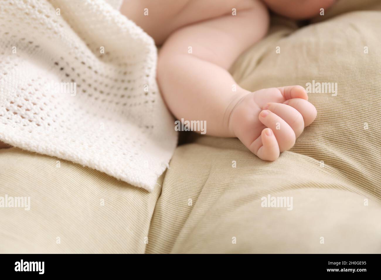 Adorable baby arm on bed, closeup Stock Photo - Alamy