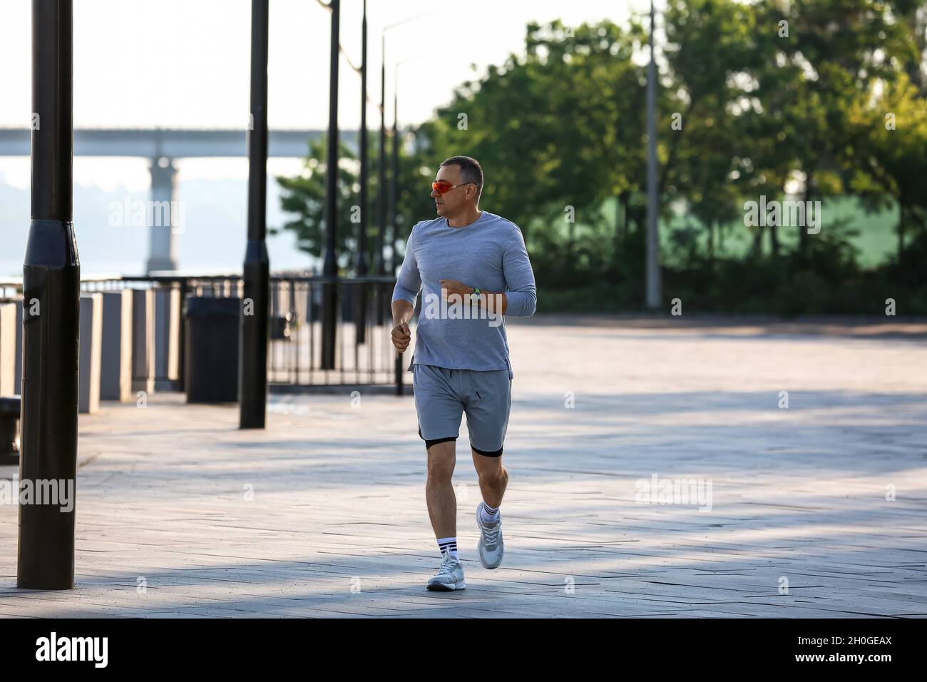 Sporty mature man in sunglasses running outdoors Stock Photo - Alamy