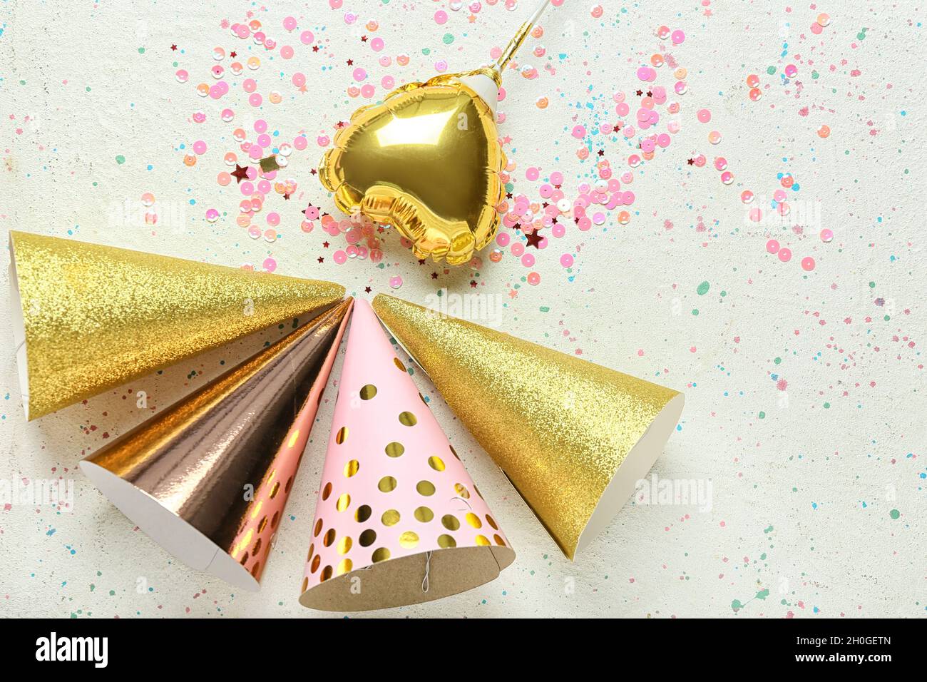 Balloon with party hats and confetti on light background Stock Photo ...