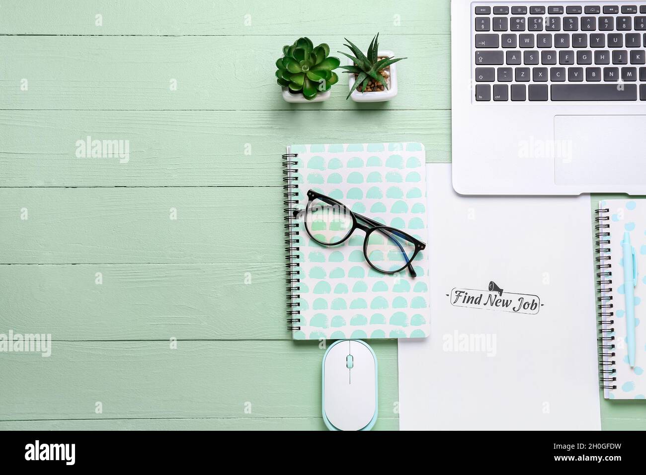 Paper sheet with text FIND NEW JOB, laptop and notebooks at workplace ...