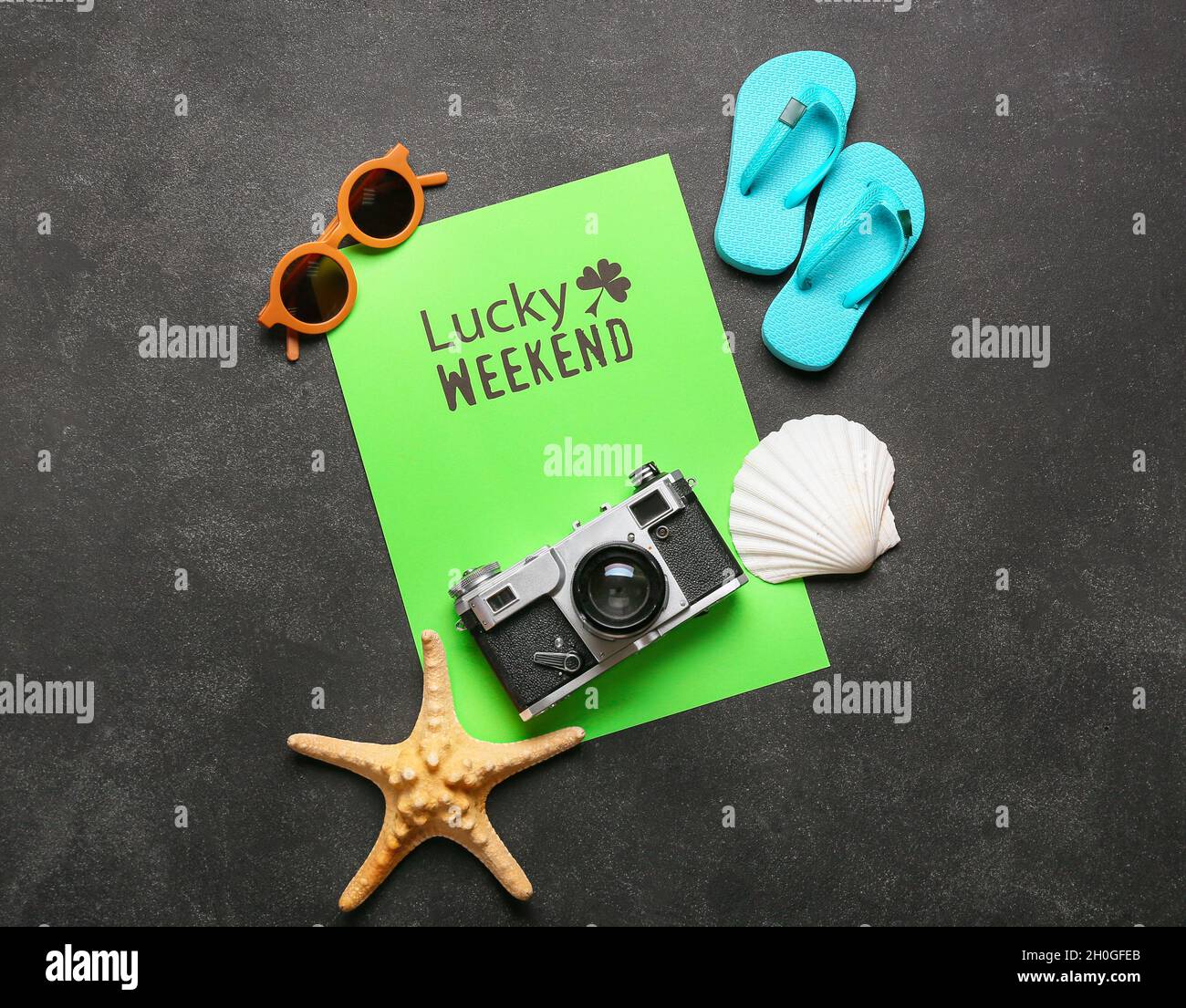 Paper sheet with text LUCKY WEEKEND with photo camera, sunglasses and ...