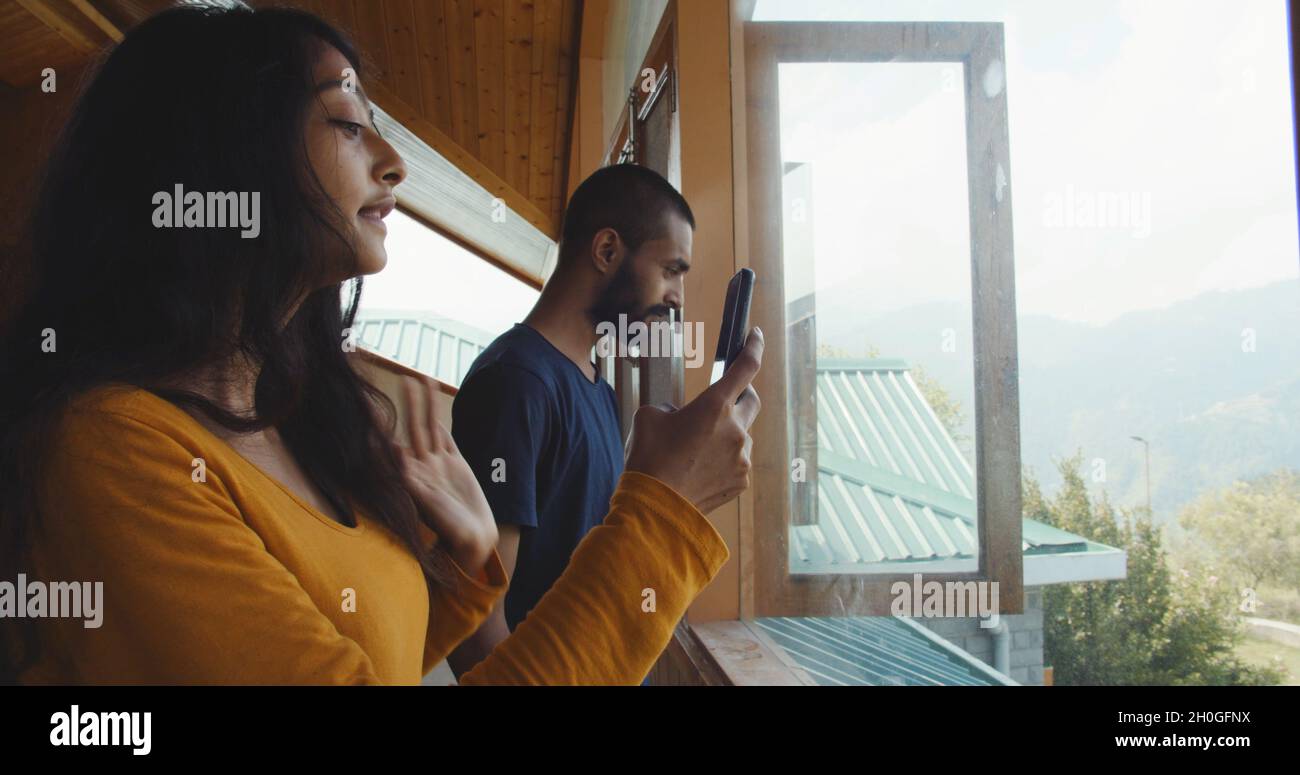 Guy and girl are taking pictures of outdoor scenes from the window ...