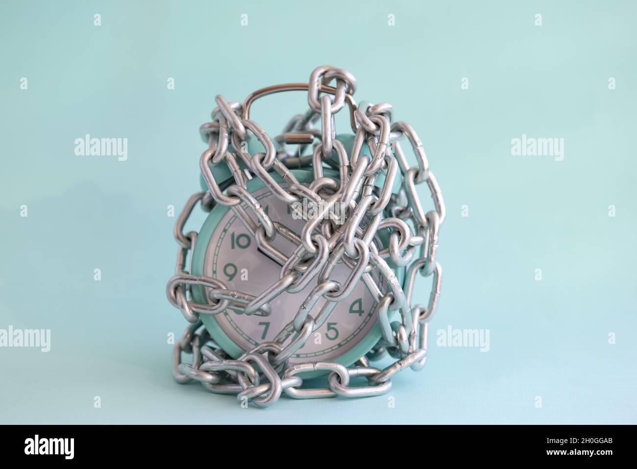 Turquoise alarm clock is wrapped in chrome chain closeup Stock Photo ...