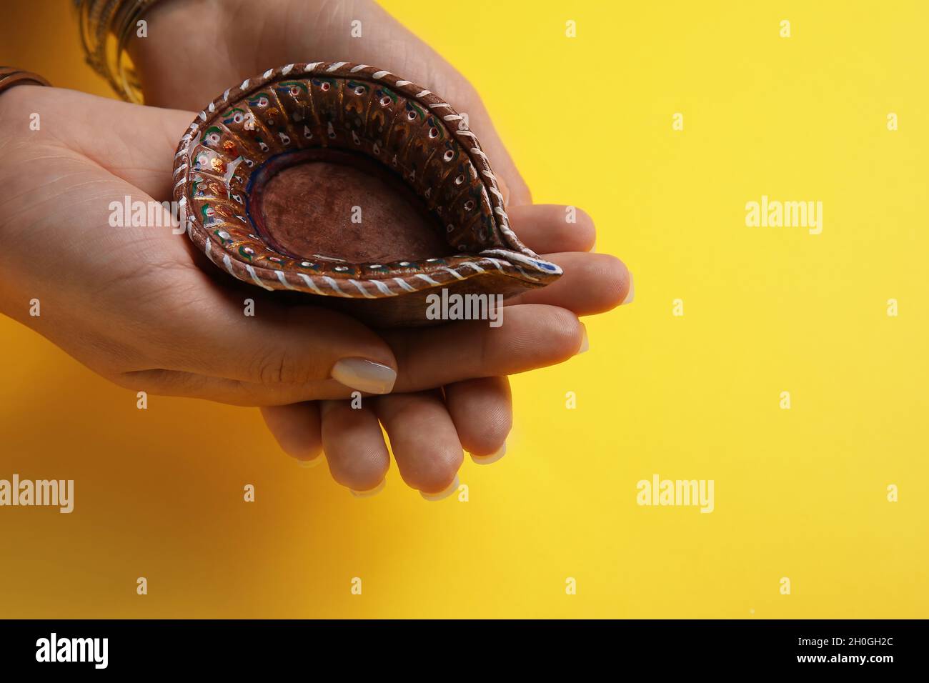 Female hands with diya lamp for Diwali on color background Stock Photo ...