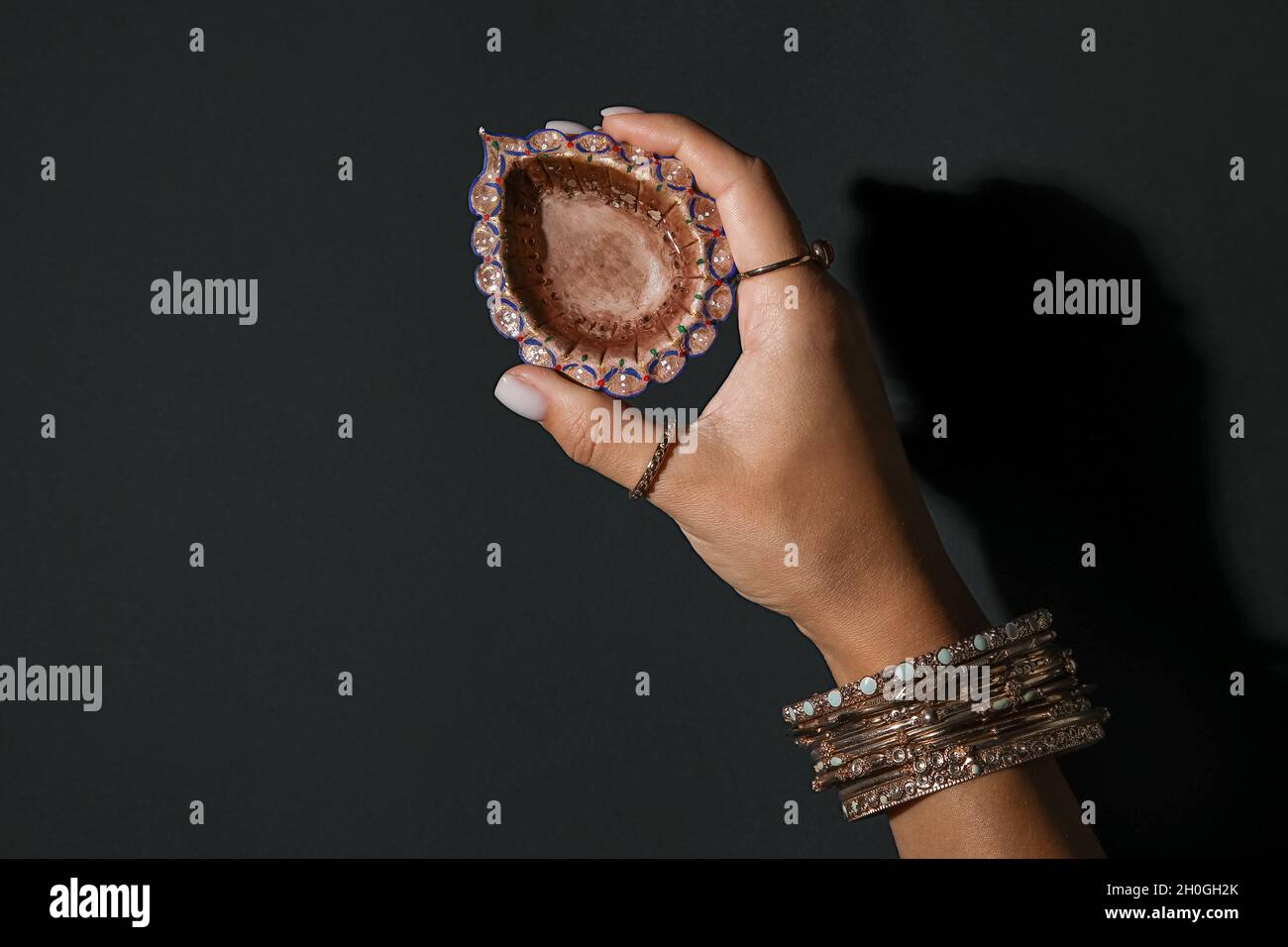 Female hand with diya lamp for Diwali on dark background Stock Photo ...