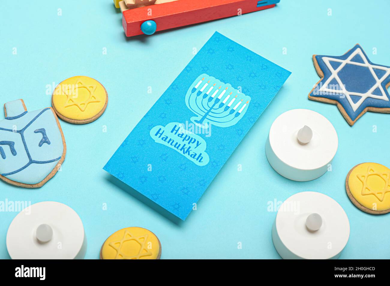 Different symbols of Hanukkah and greeting card on color background ...