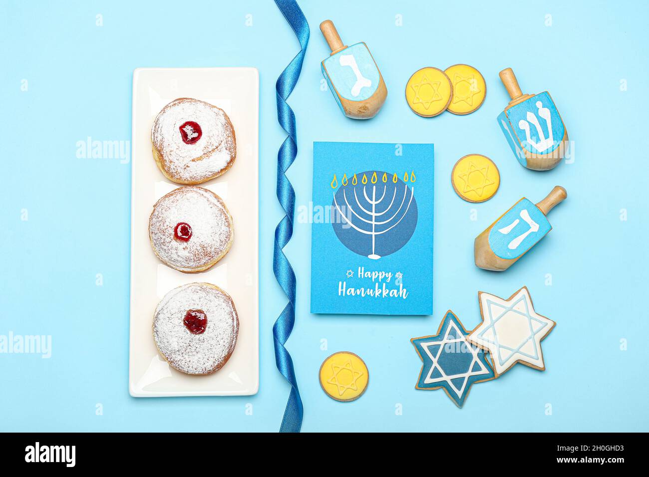 Different symbols of Hanukkah and greeting card on color background ...