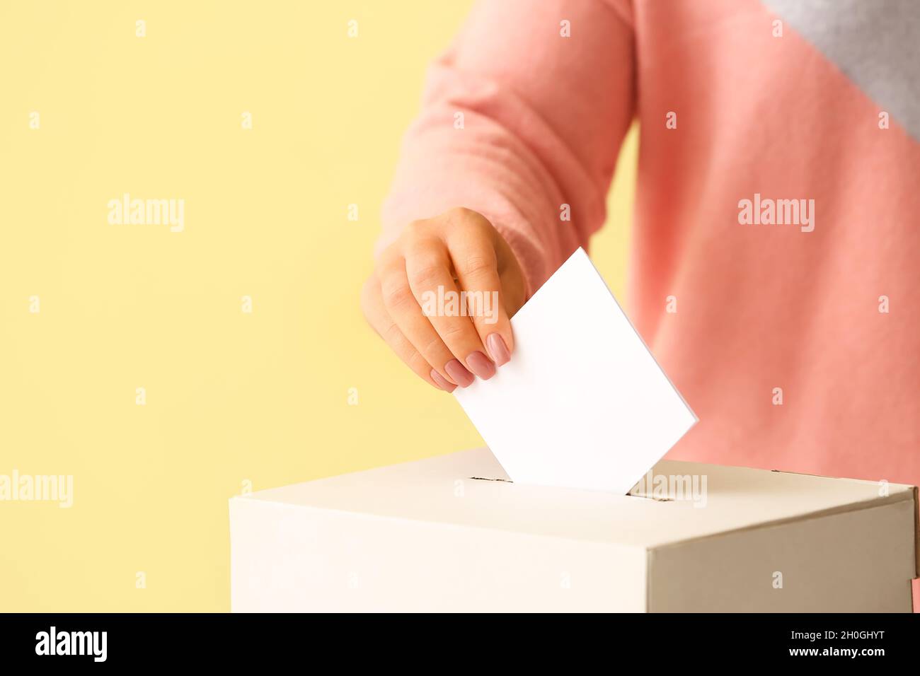 Voting woman near ballot box on color background Stock Photo - Alamy