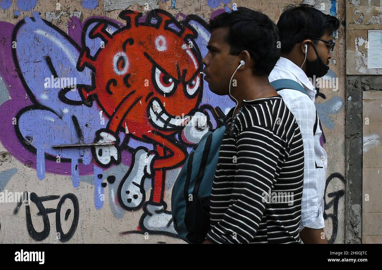 People walk past a graffiti painted to create awareness about the ...