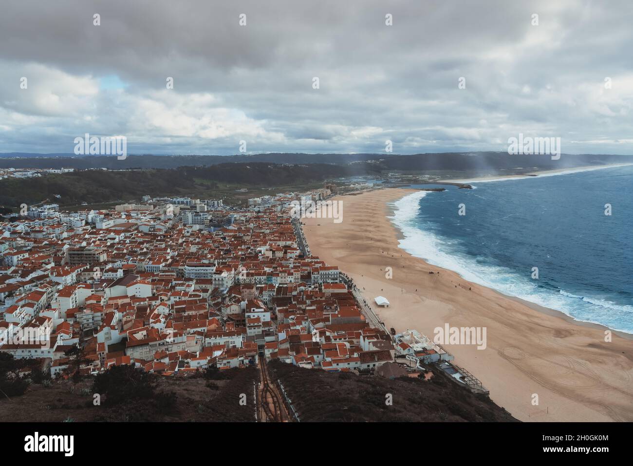 Aerial view of Nazare City and Praia da Nazare Beach with rain on the ...