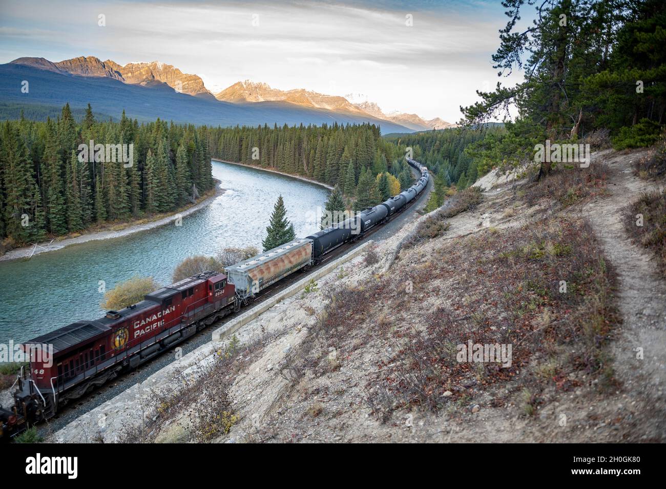 Train running beside the Bow River with Mount Temple in the distance ...